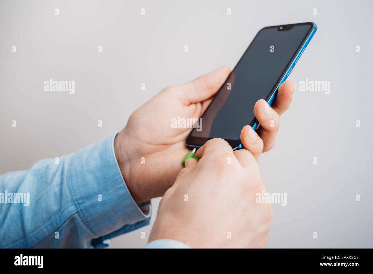 Hand connecting cable to mobile phone Stock Photo - Alamy