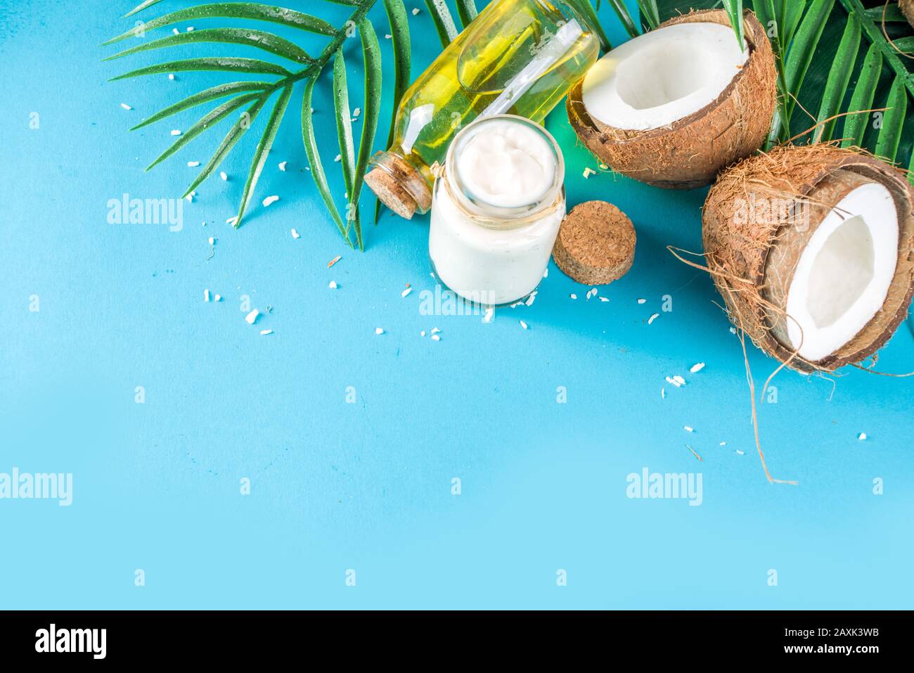 Coconut oil in glass jar with tropical leaves and fresh coconut ...