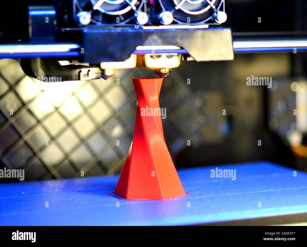 3D printer printing isolated volume triangular object red color on the ...