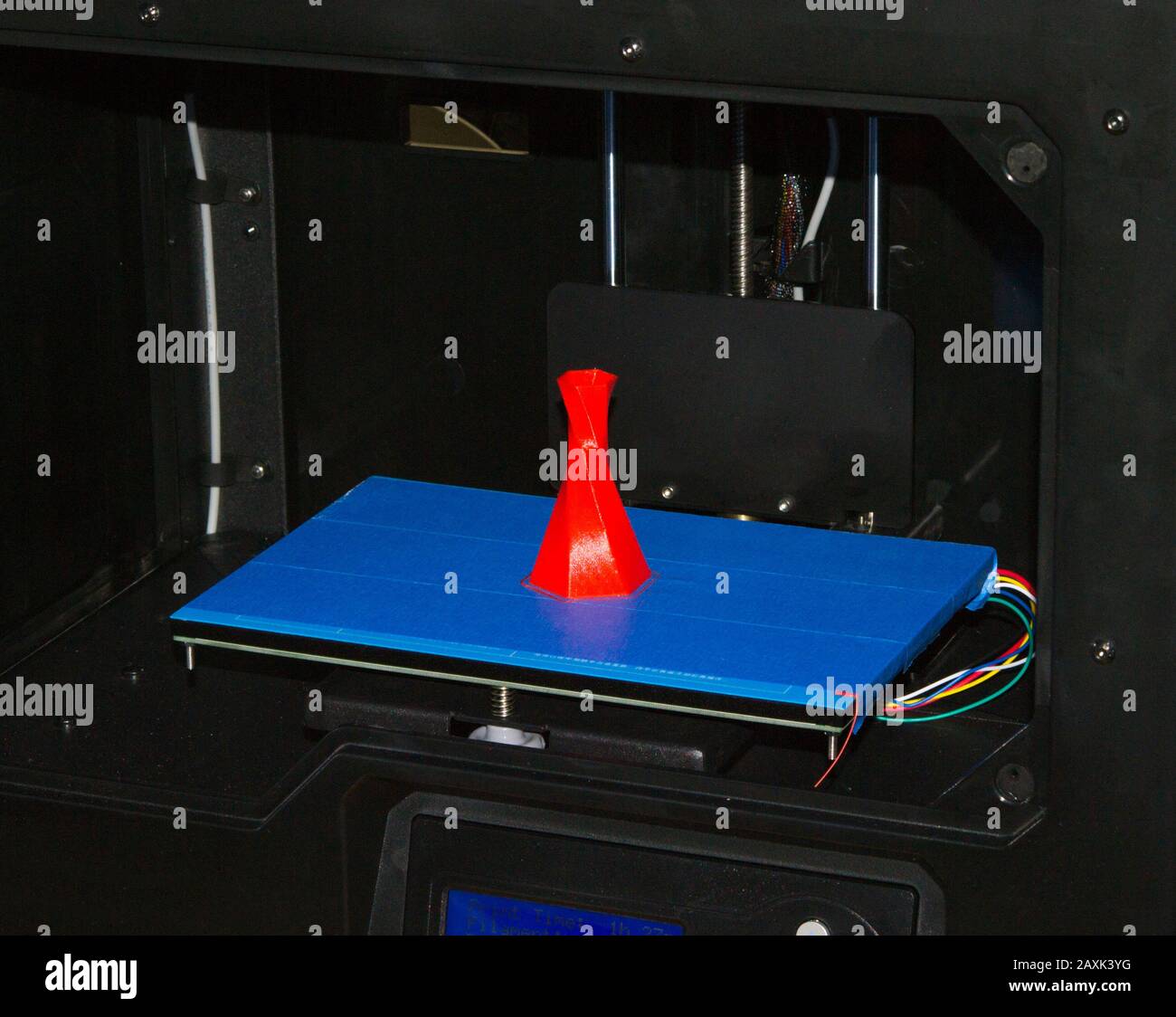 3D printer printing isolated volume triangular object red color on the ...