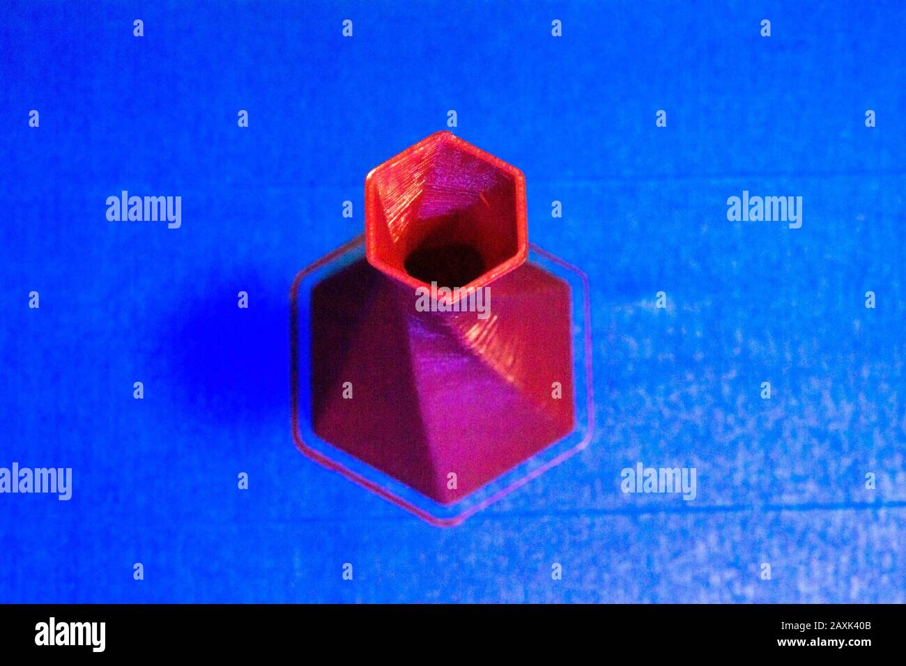 3D printer printing object red color on the basis of blue top view ...