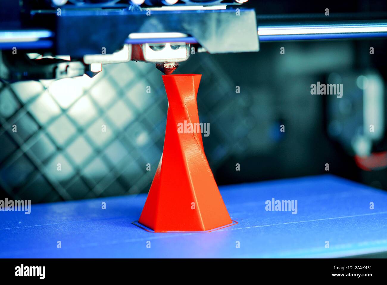 3D printer printing isolated volume triangular object red color on the ...