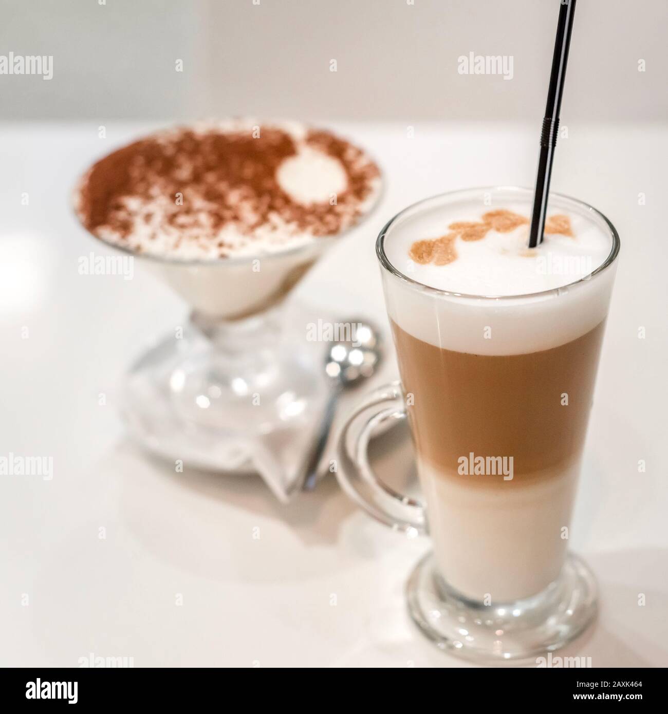 coffee latte with frothy milk in tall glass, rustic style, white wood ...