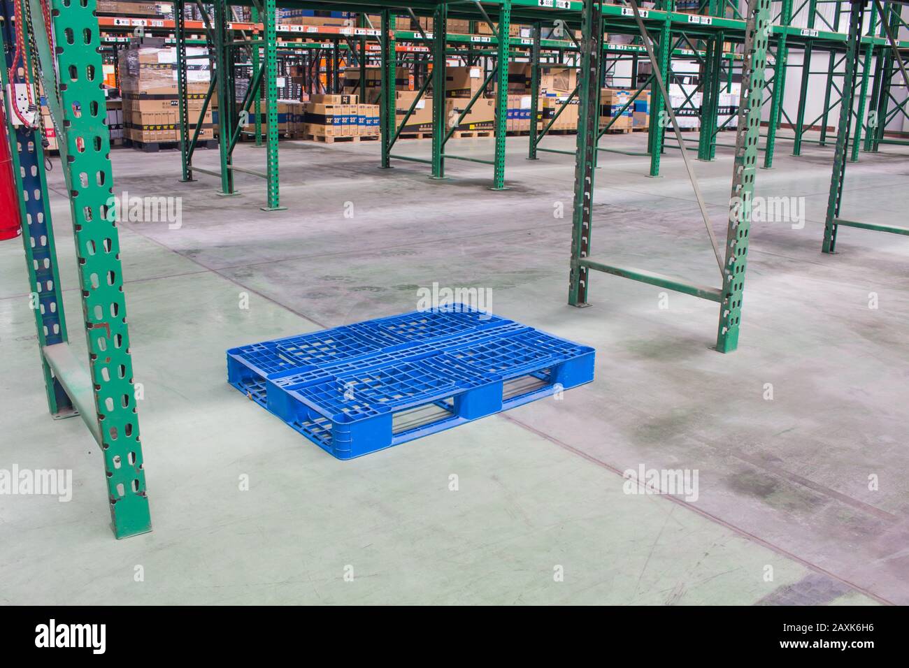 Empty pallet in warehouse interior with shelves, pallets and boxes ...