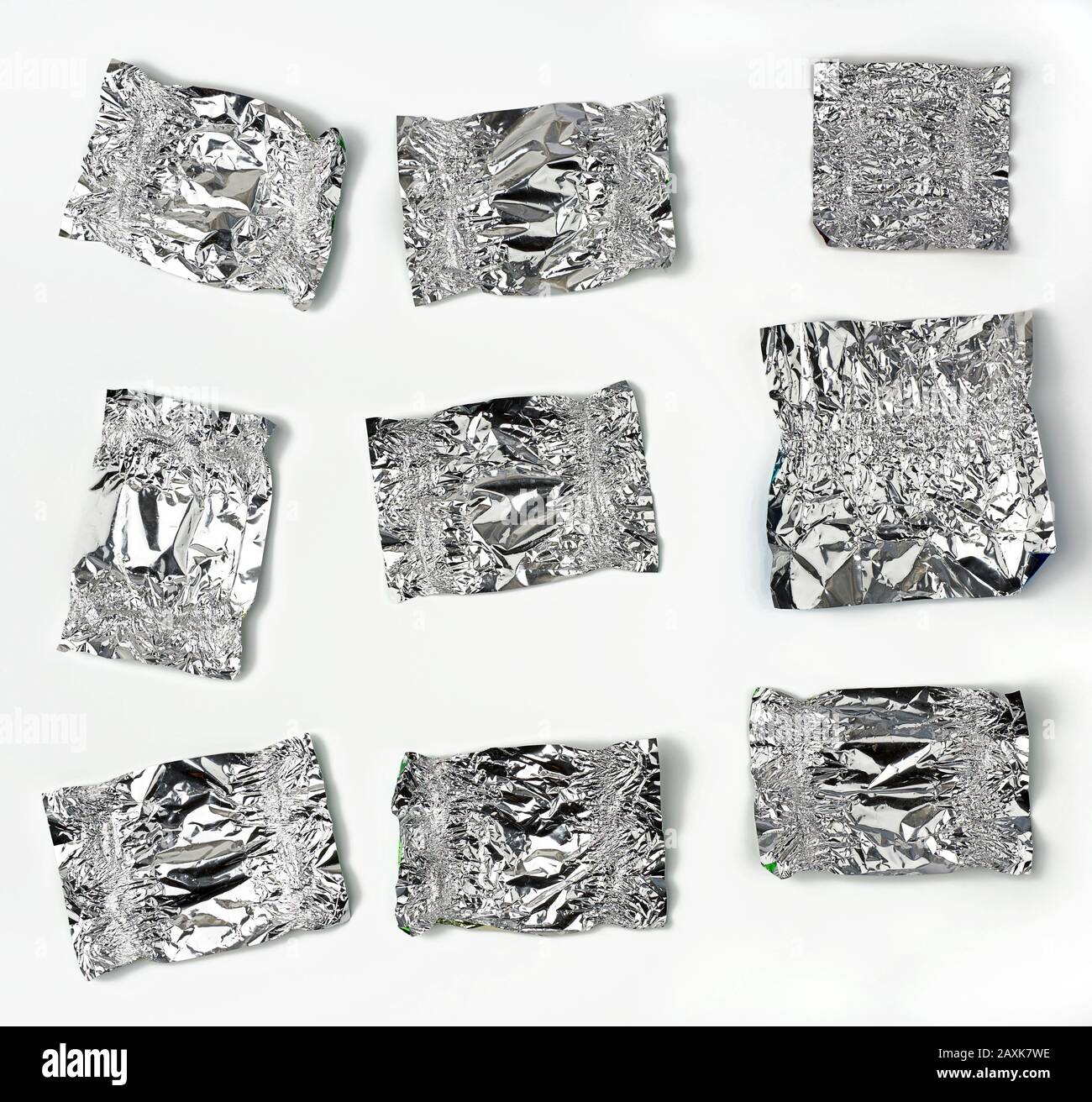 various crumpled foil used candy wrappers on a white background, top ...