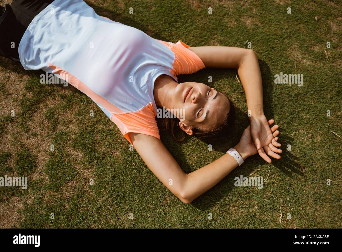 Fitness sport girl resting after intensive run laying on grass Stock ...