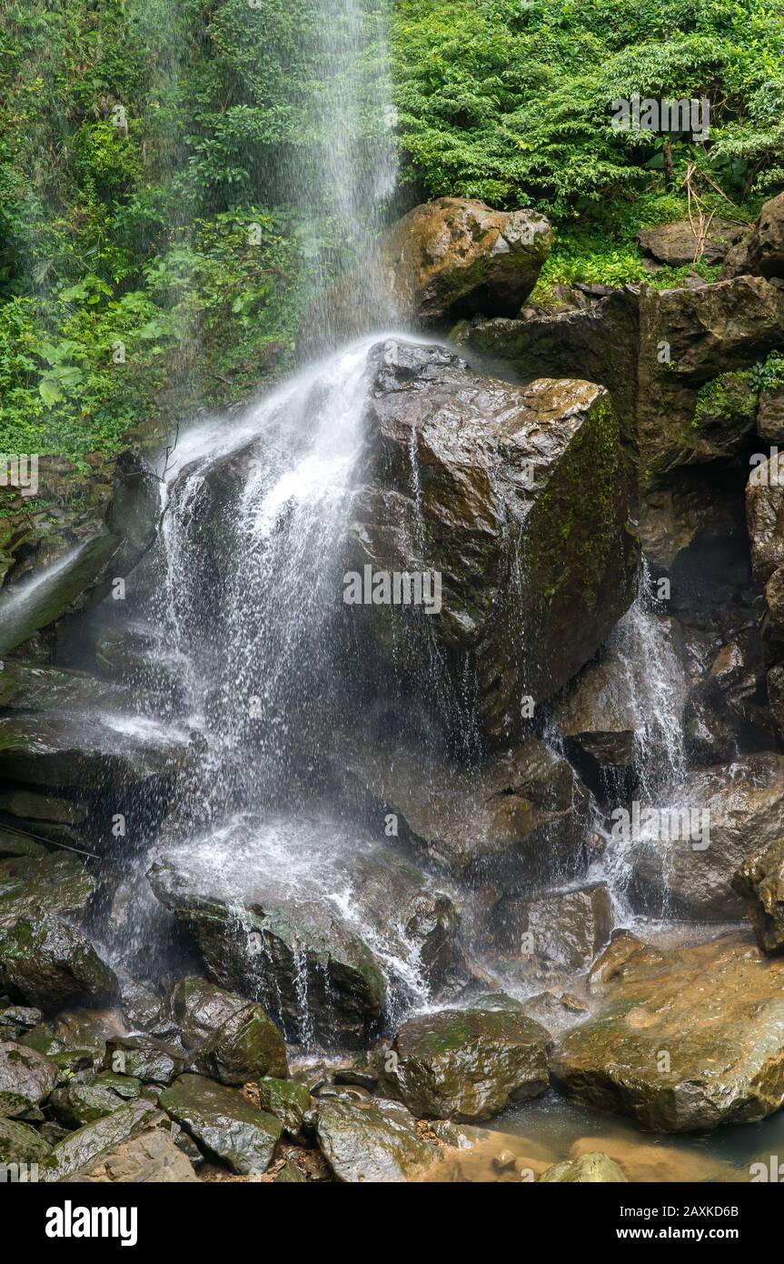 Small waterfall hitting and splash on the surface of hard rocks, near ...