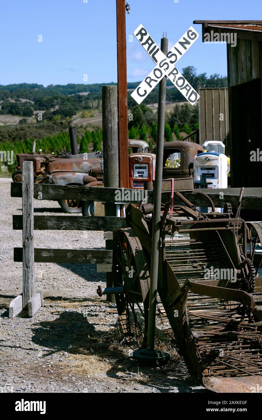 Railroad Crossing sign and old rusty cars with gas pumps on a farm in ...