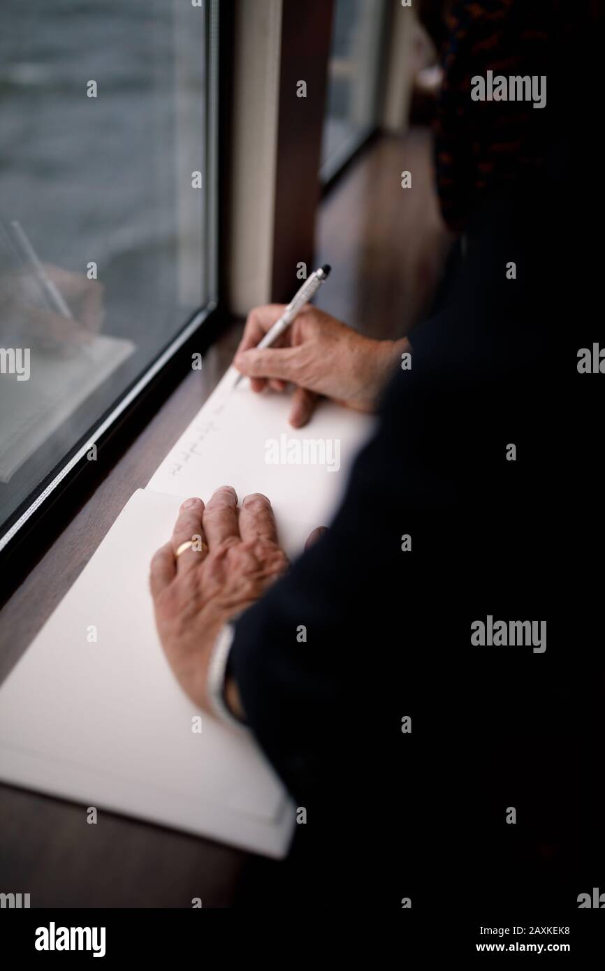 Aged man writing in a formal book Stock Photo - Alamy