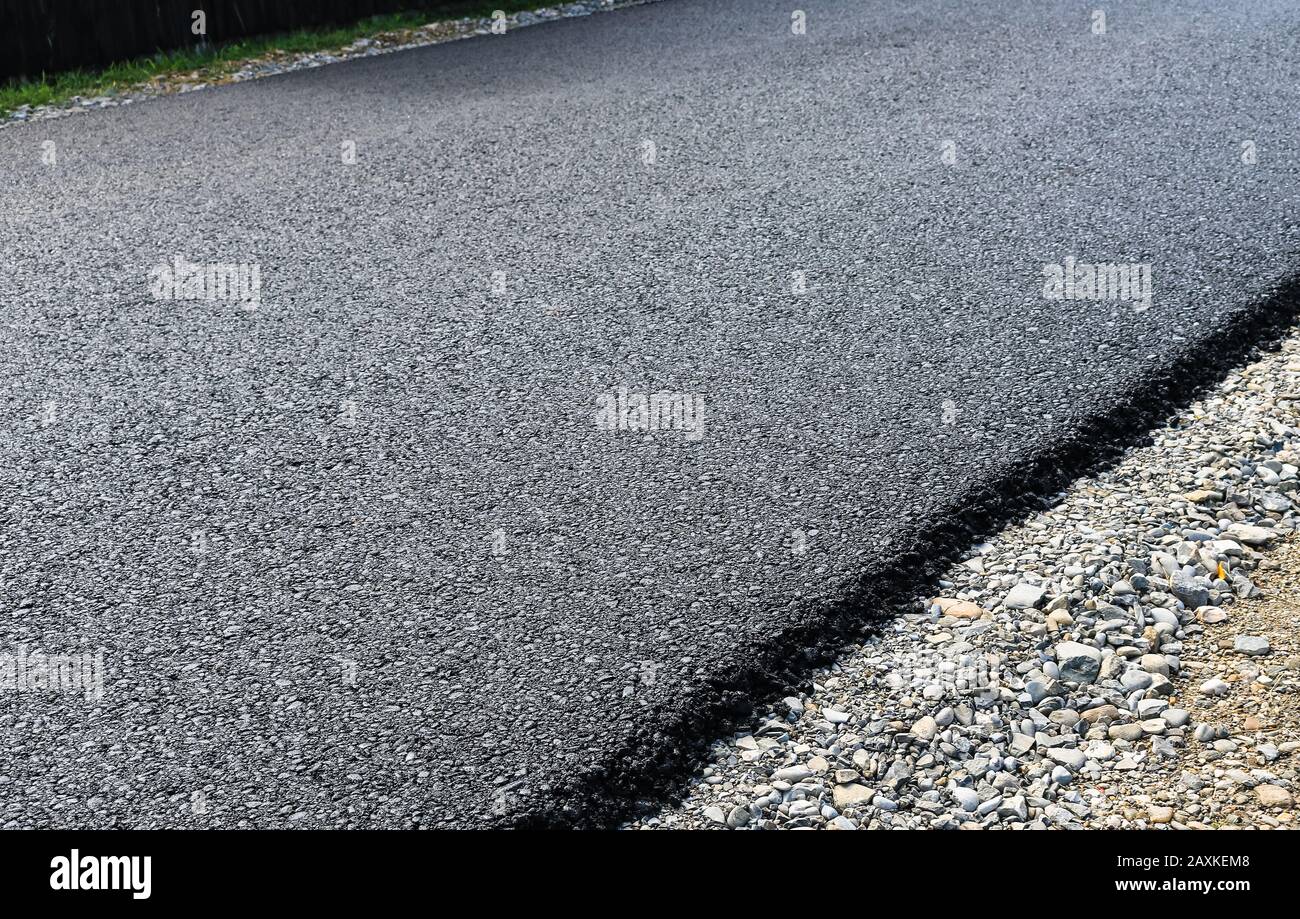 New layer of asphalt road under construction with support from the ...
