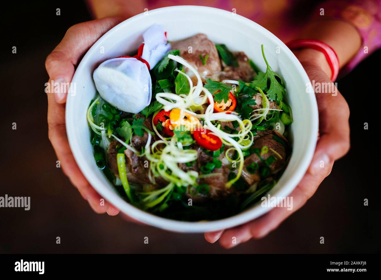High angle close up of person holding bowl of beef pho Stock Photo - Alamy