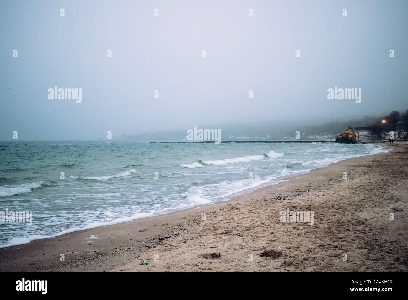 Urban seascape with sandy beach in cold weather with fog Stock Photo ...