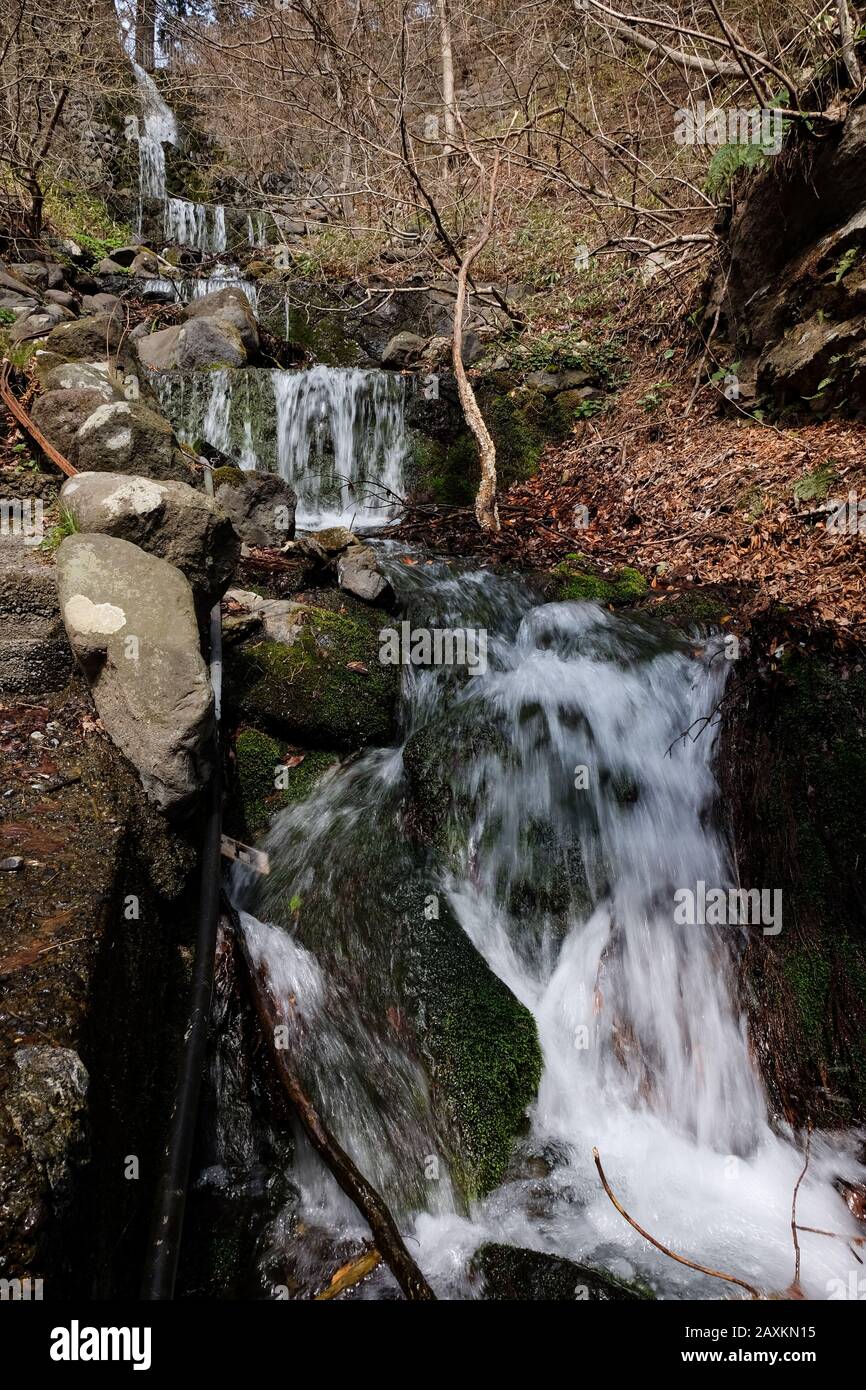 Vertical shot of a small waterfalls with a series of cascades from a ...