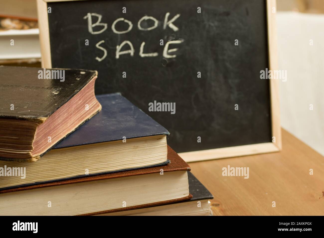 Stack of old books with a book sale sign written on a chalkboard Stock ...