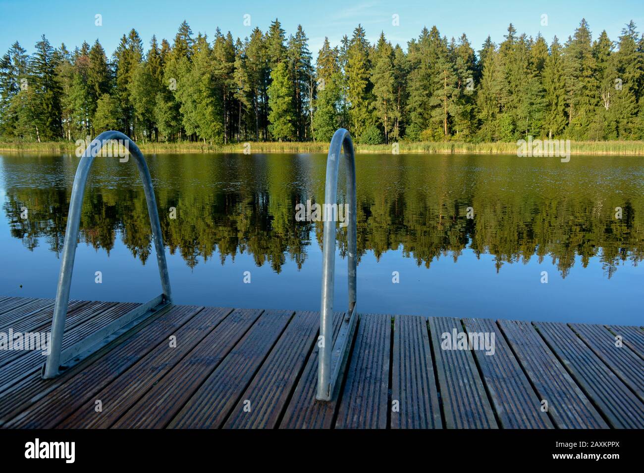 Peaceful summer afternoon on a beautiful and clean lake. Steel ladders ...