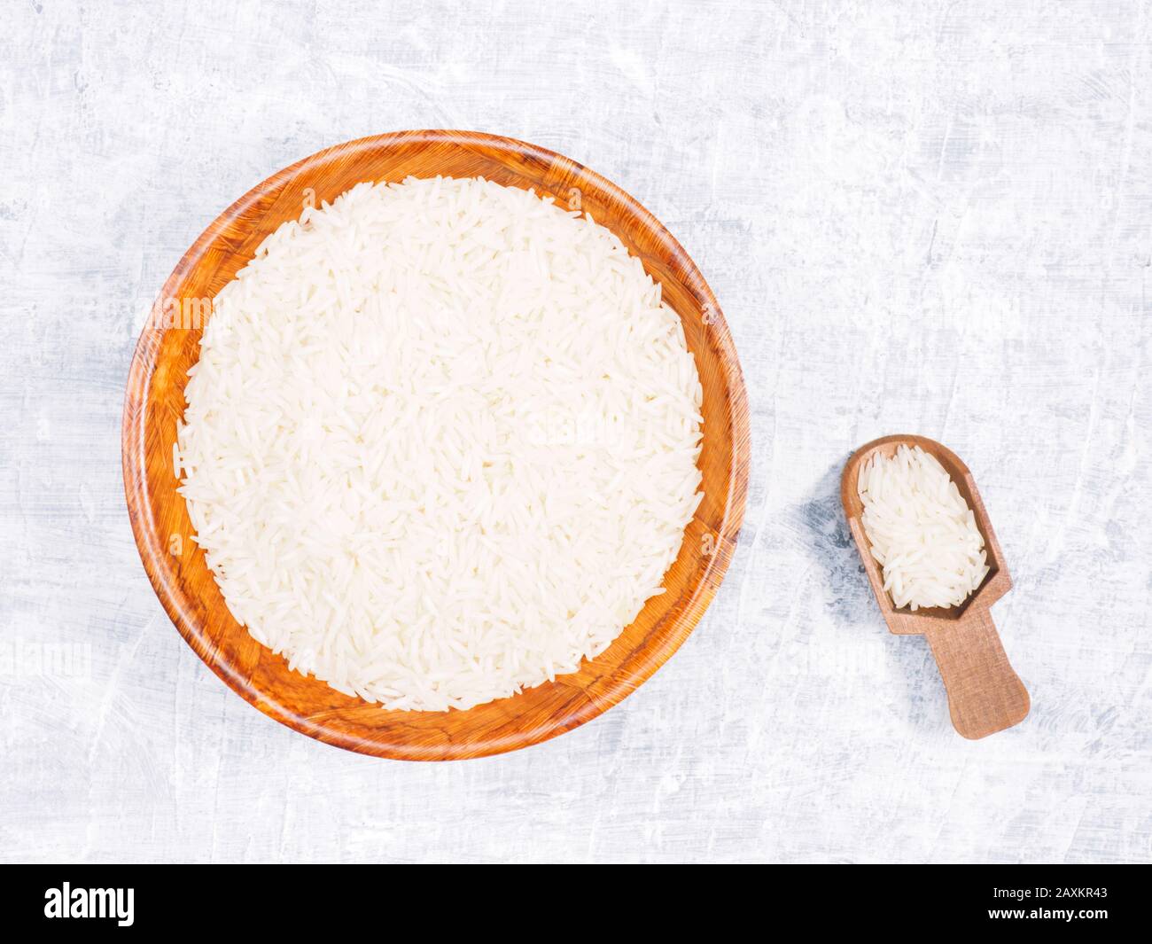 Indian long grain Basmati rice in brown wooden bowl and scoop on white ...