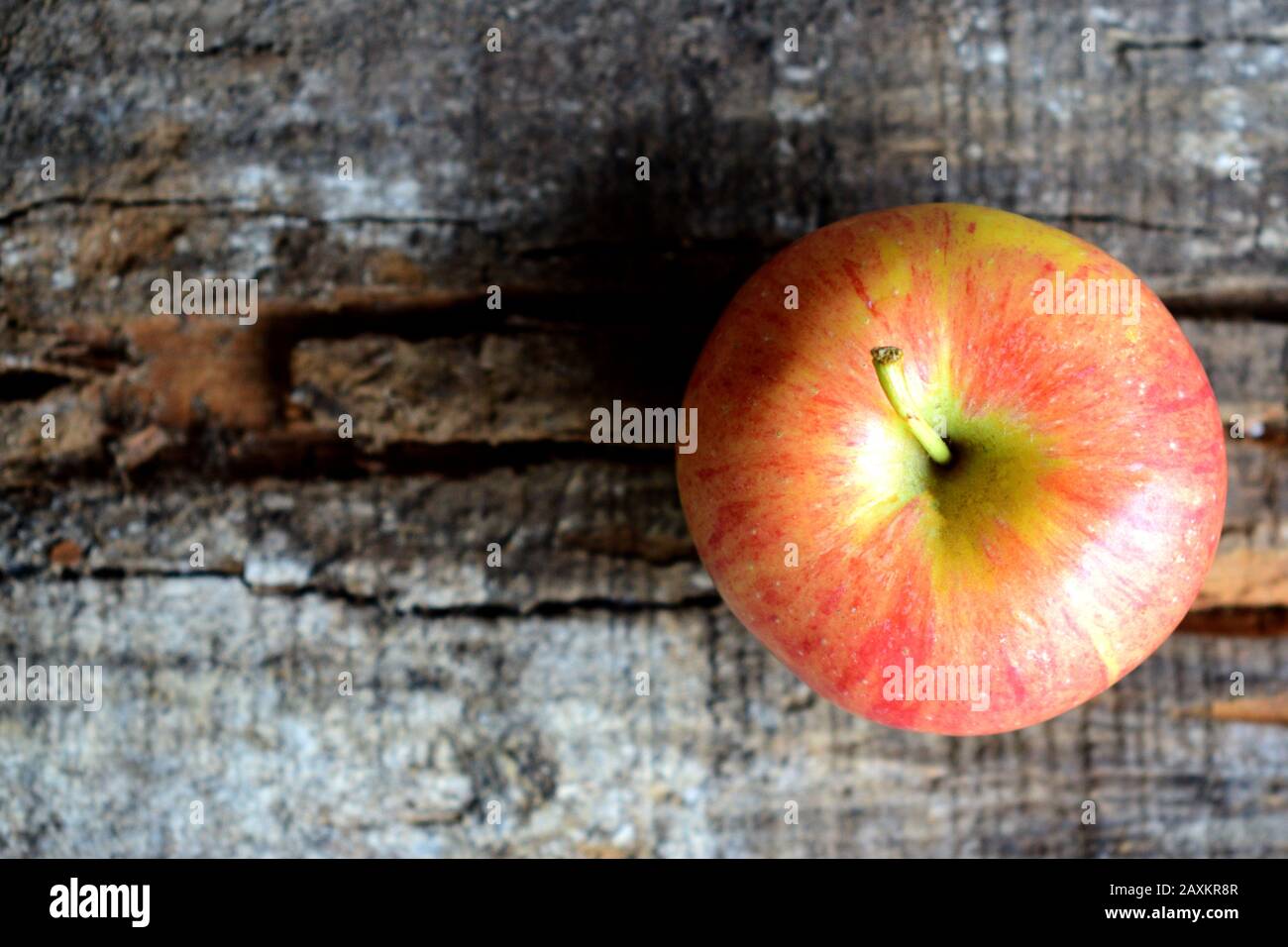 Vertical view of an apple on top of a piece of unfocused piece of old ...