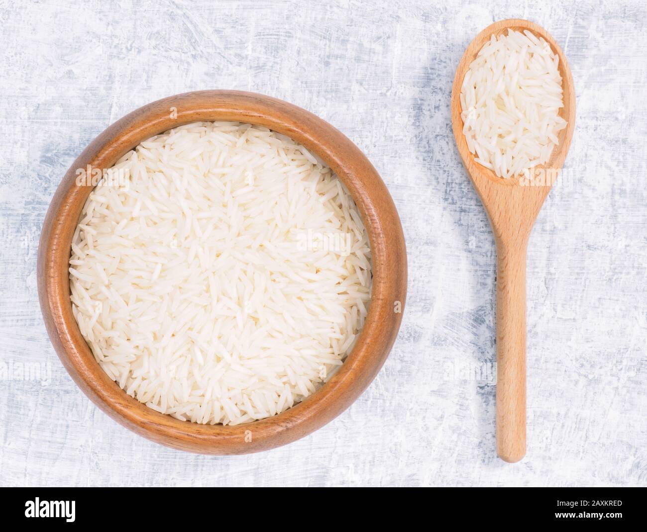 Indian long grain Basmati rice in brown wooden bowl and spoon on white ...