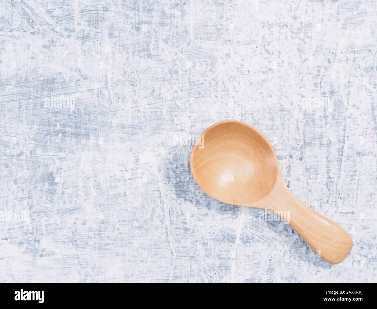 Wooden spoon on white concrete background Stock Photo - Alamy