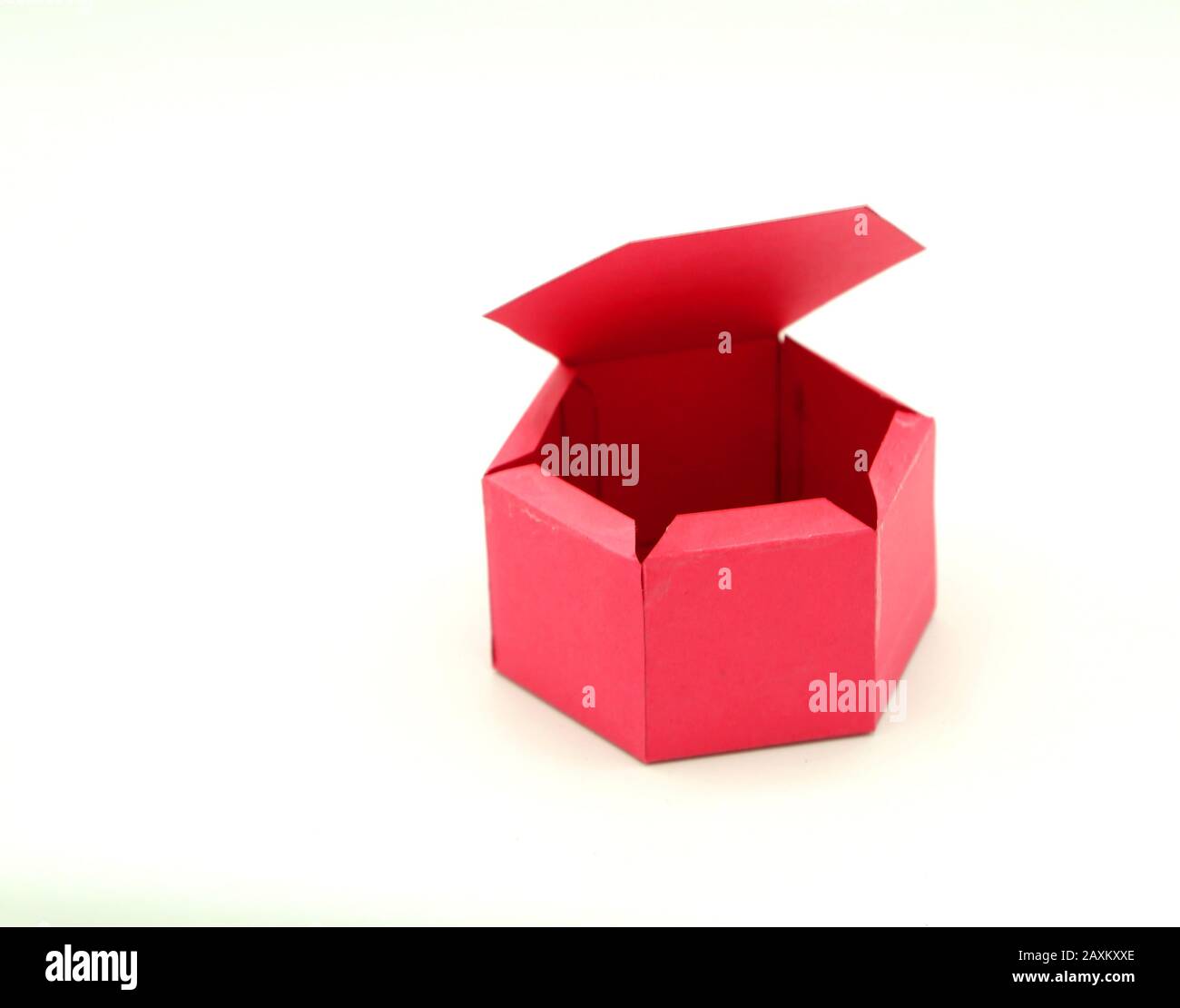 Geometric shape cut out of paper and photographed on grey background ...