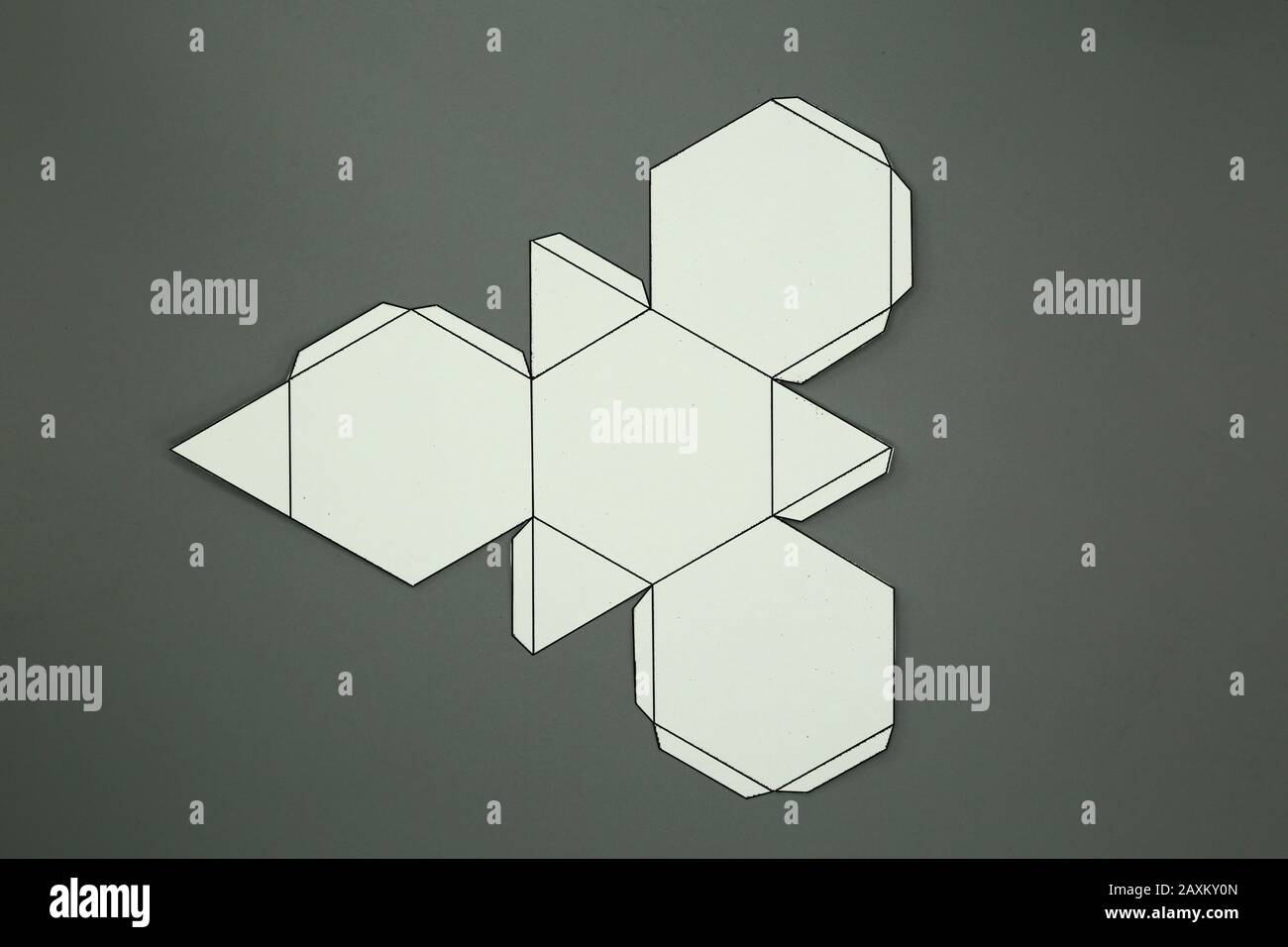 Geometric shape cut out of paper and photographed from above on grey ...