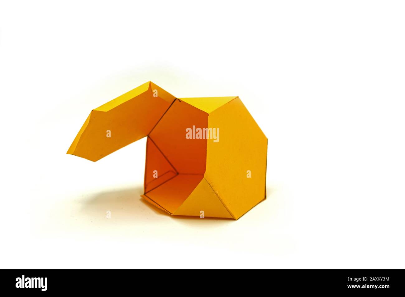 Geometric shape cut out of yellow paper and photographed on white ...