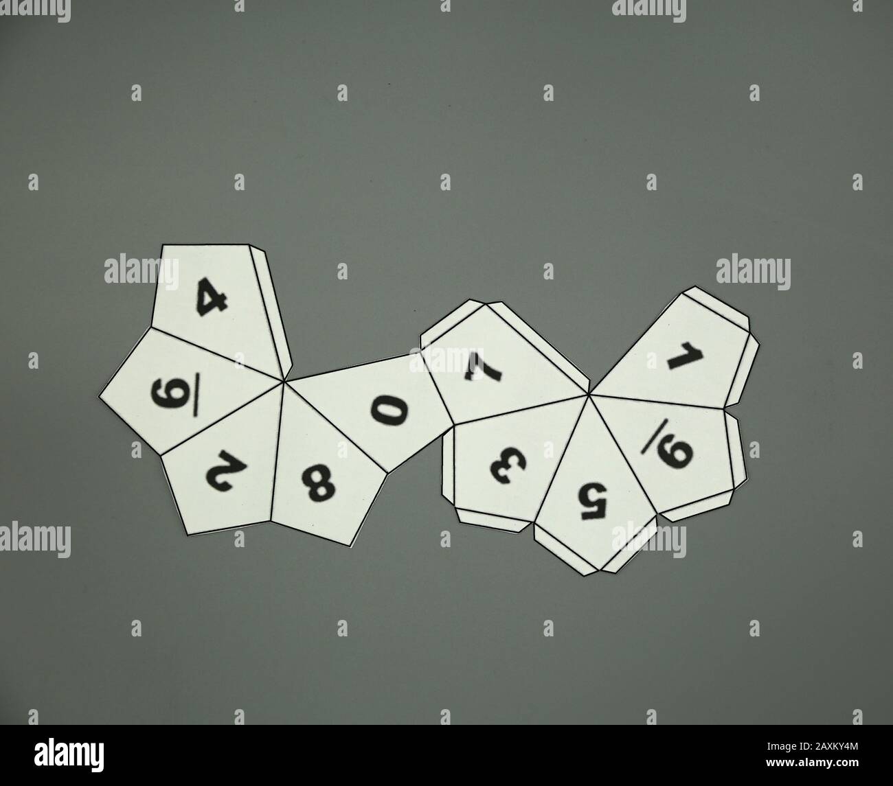 Geometric shape cut out of paper and photographed from above on grey ...