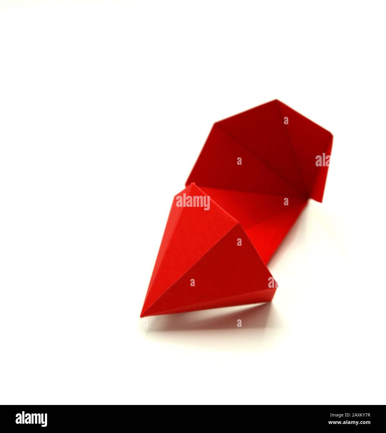 Geometric shape cut out of red paper and photographed on white ...