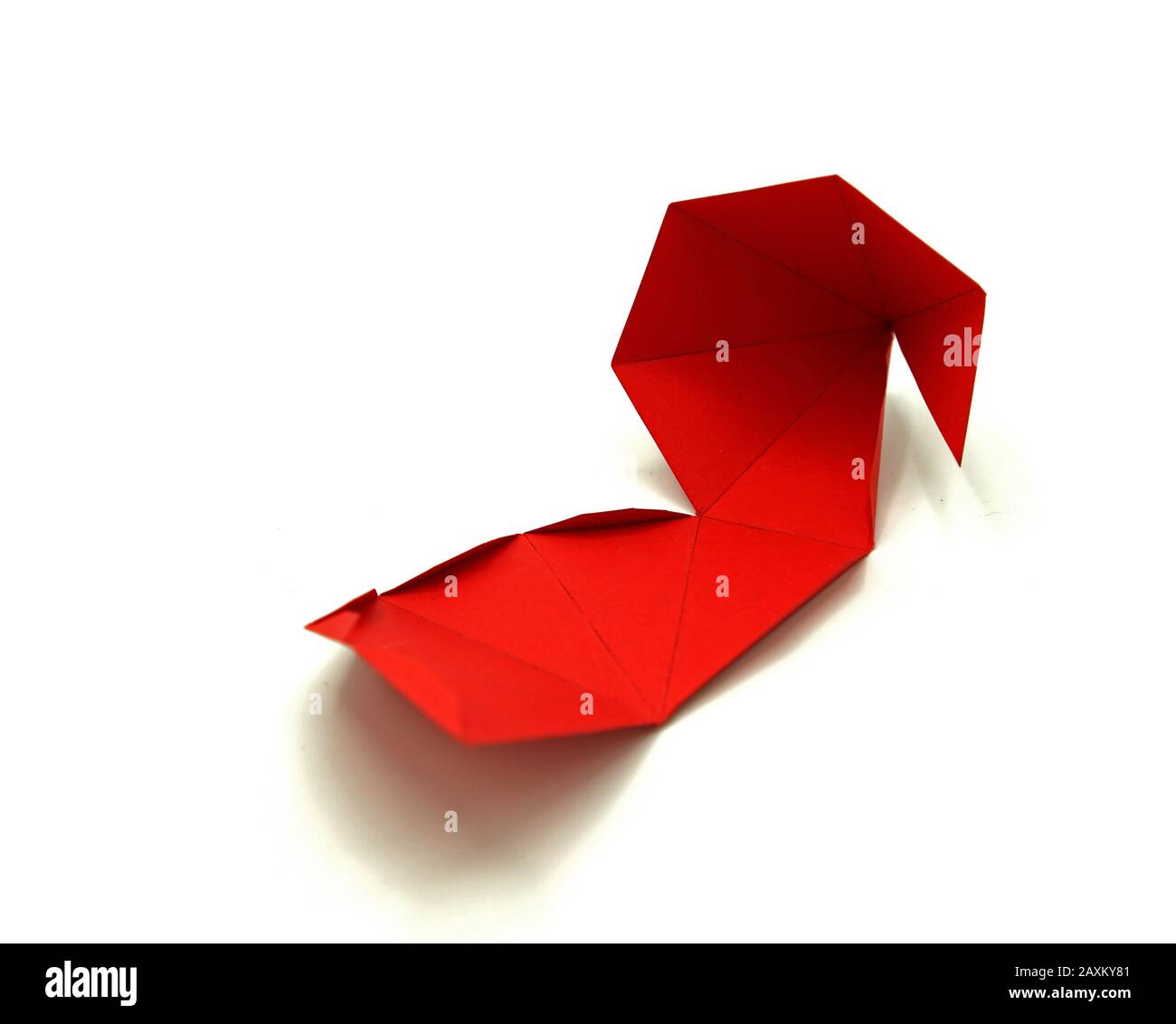 Geometric shape cut out of red paper and photographed on white ...