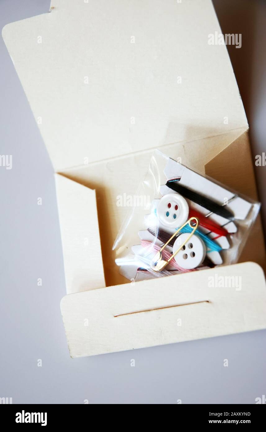 Sewing kit cardboard with buttons, needles and color thread on grey ...
