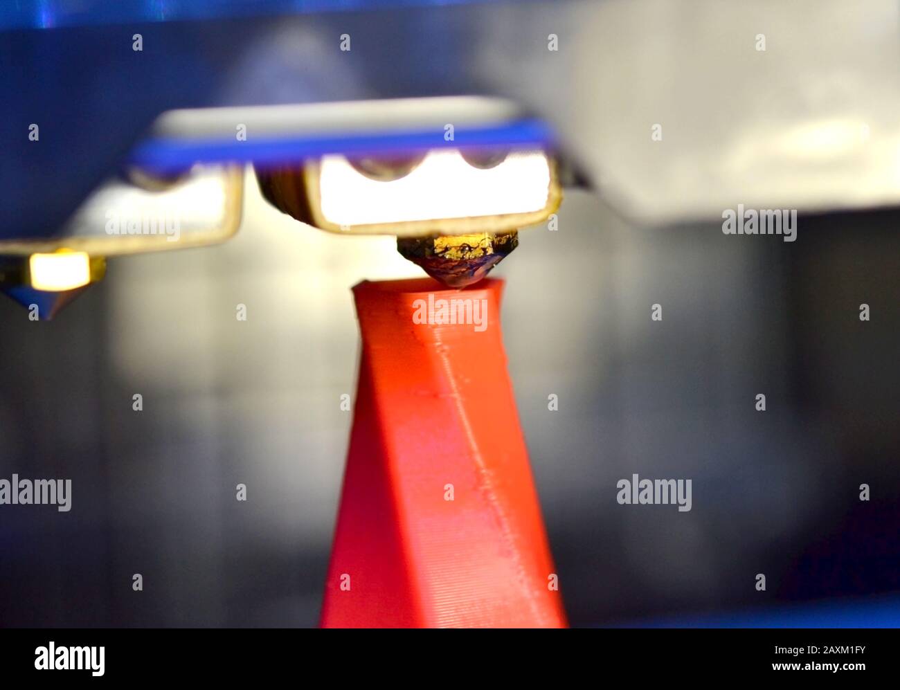 3d printer printing red model on a black background macro close-up ...