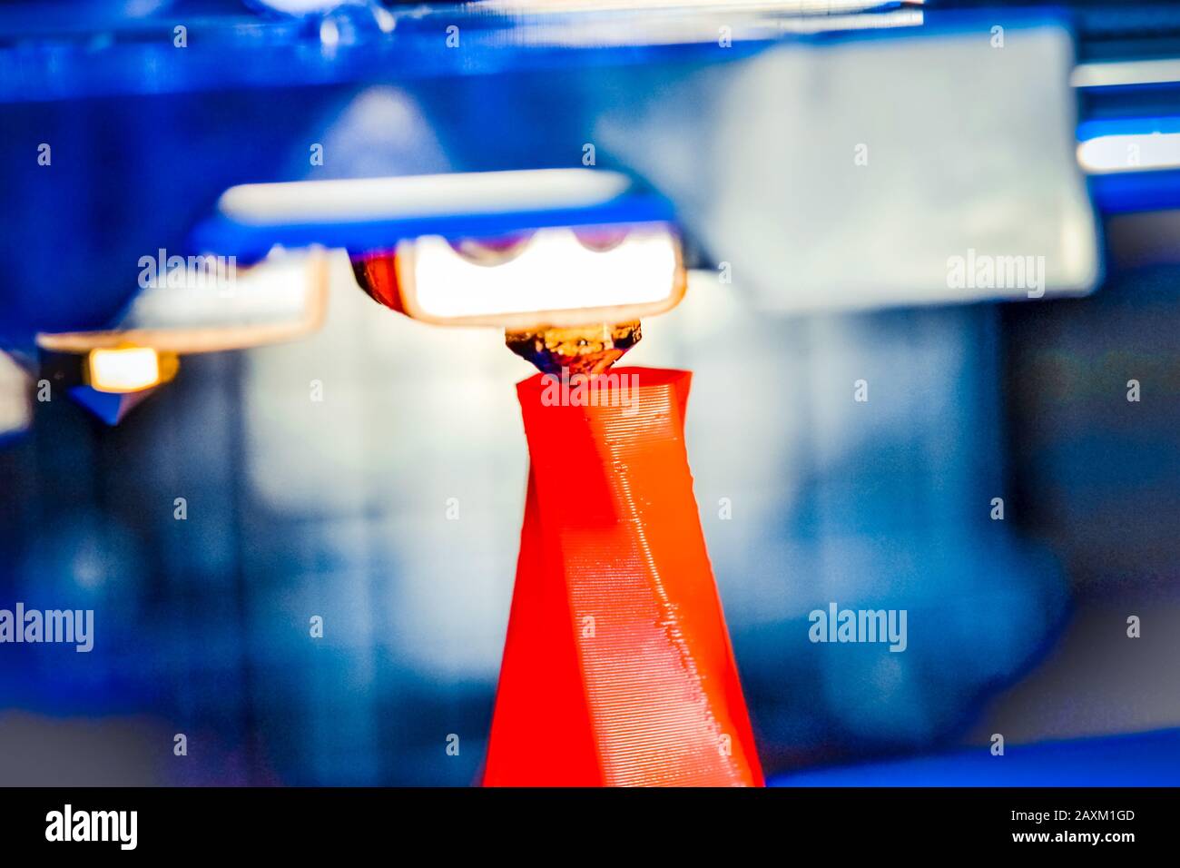3d printer printing red model on a black background macro close-up ...