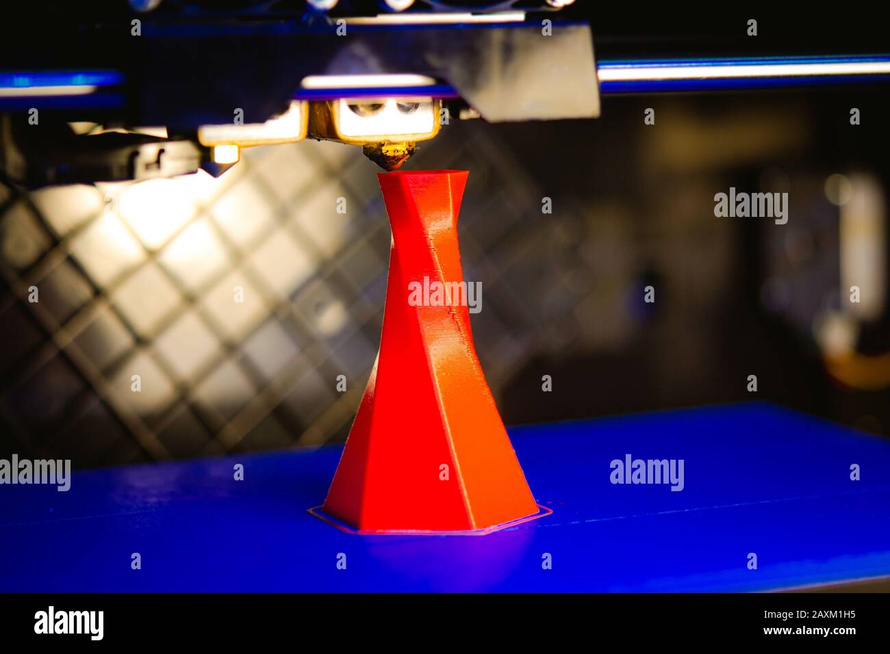 3D printer printing isolated volume triangular object red color on the ...