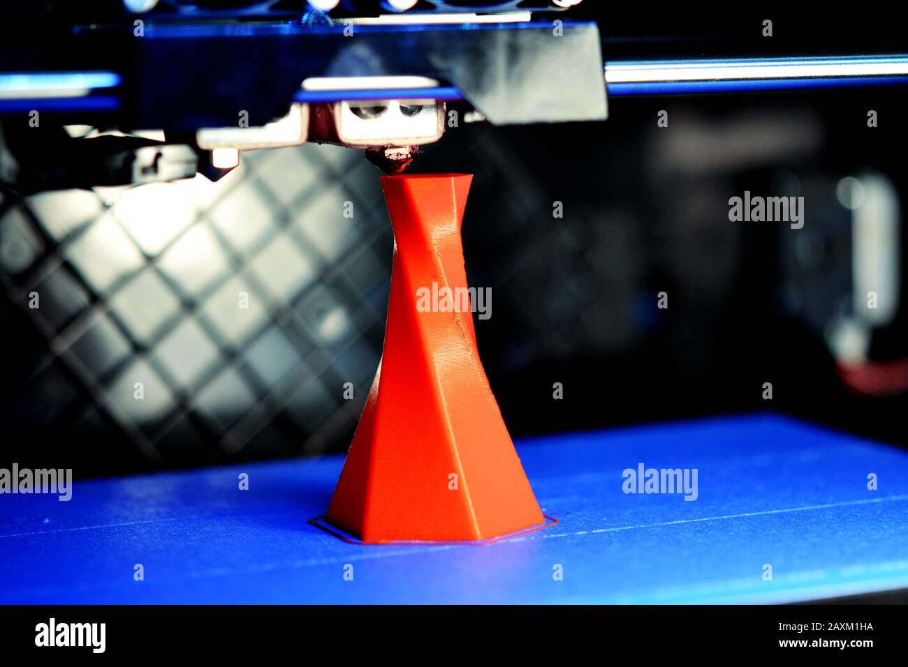 3D printer printing isolated volume triangular object red color on the ...