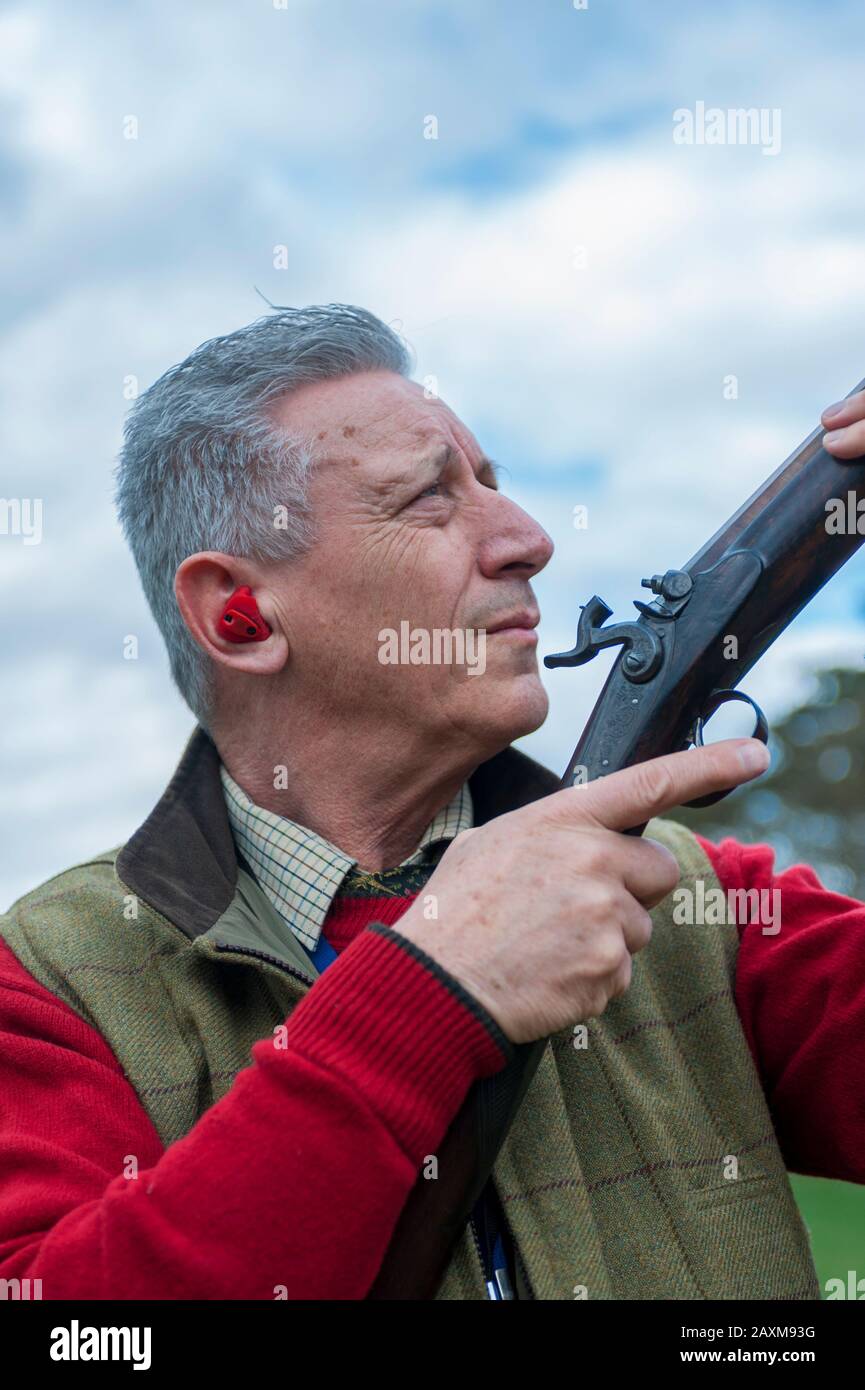 A man firing an antique black powder muzzleloading shotgun on a game ...