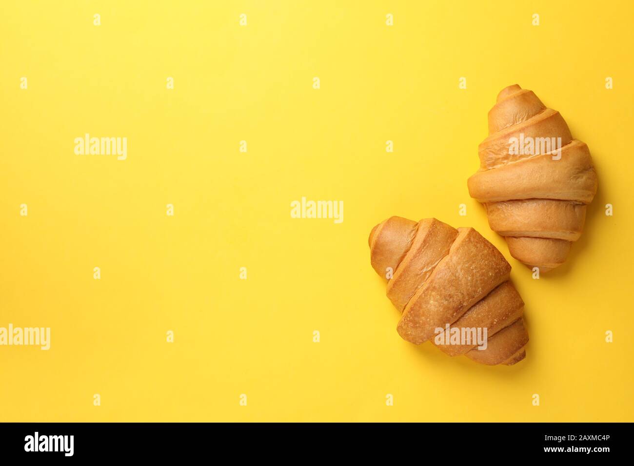 Baked croissants on yellow background, top view Stock Photo - Alamy