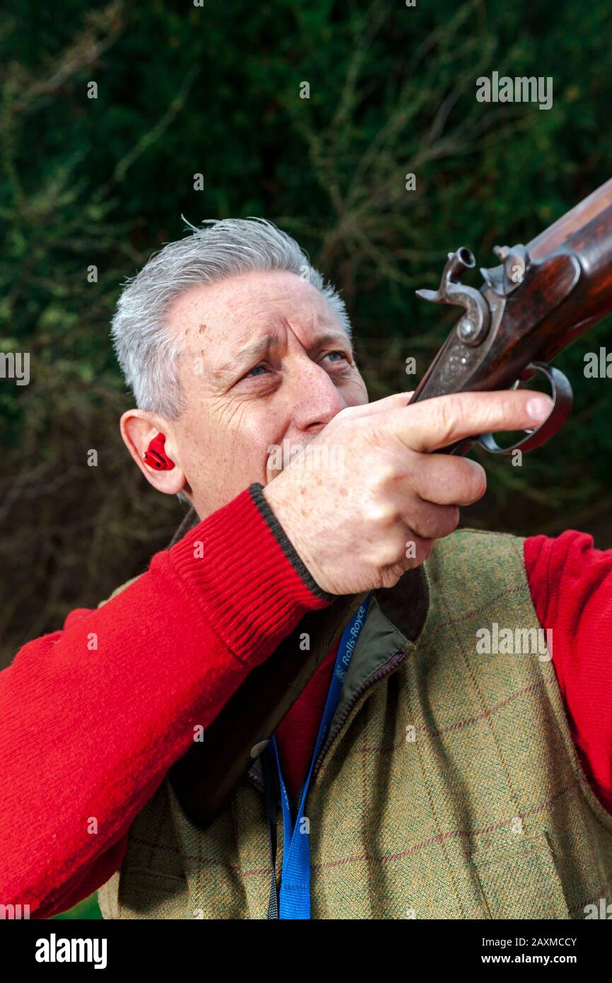 A man firing an antique black powder muzzleloading shotgun on a game ...