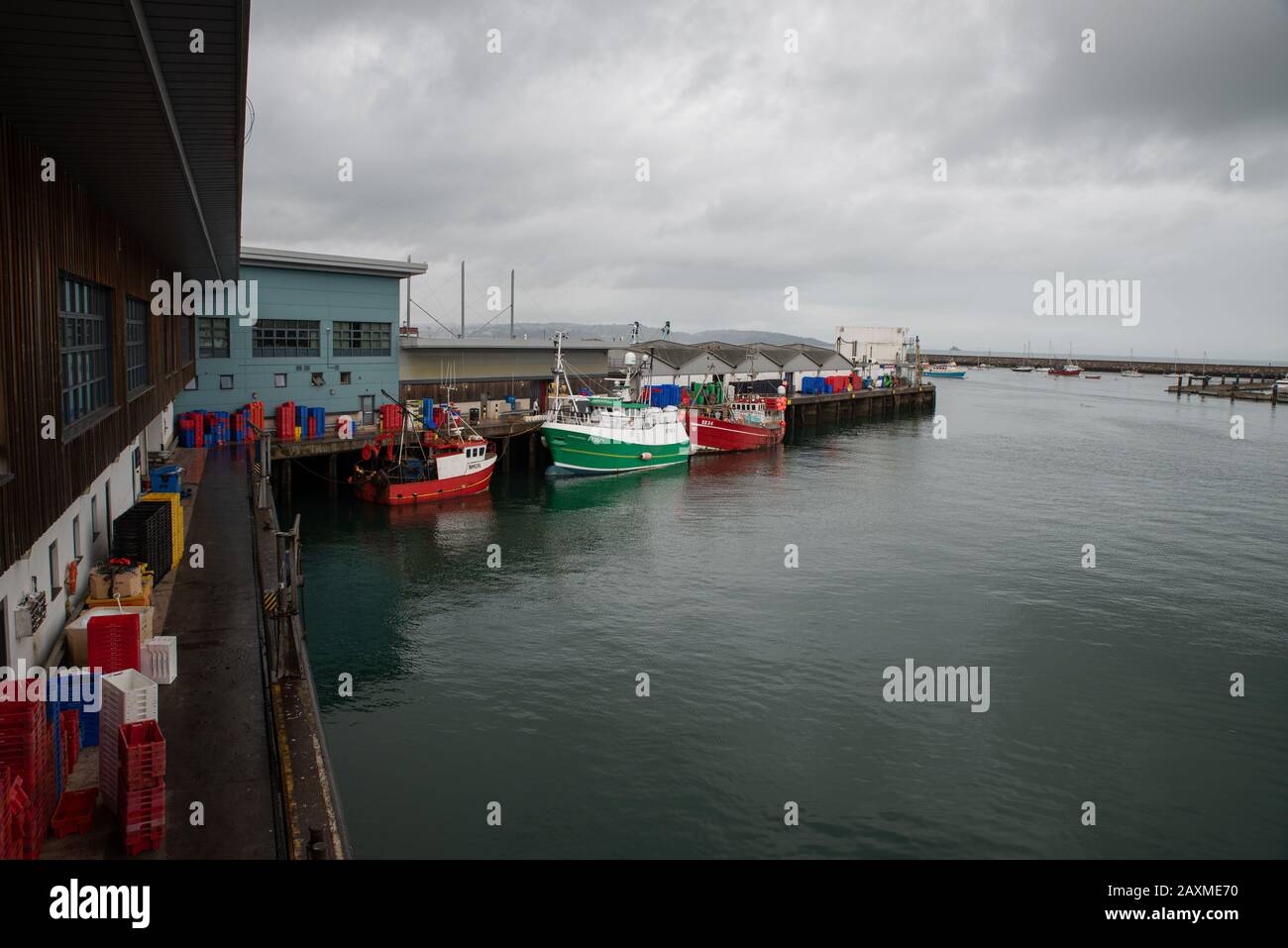 Fishing boats unloading in Brixham harbour in Devon, one of Great ...