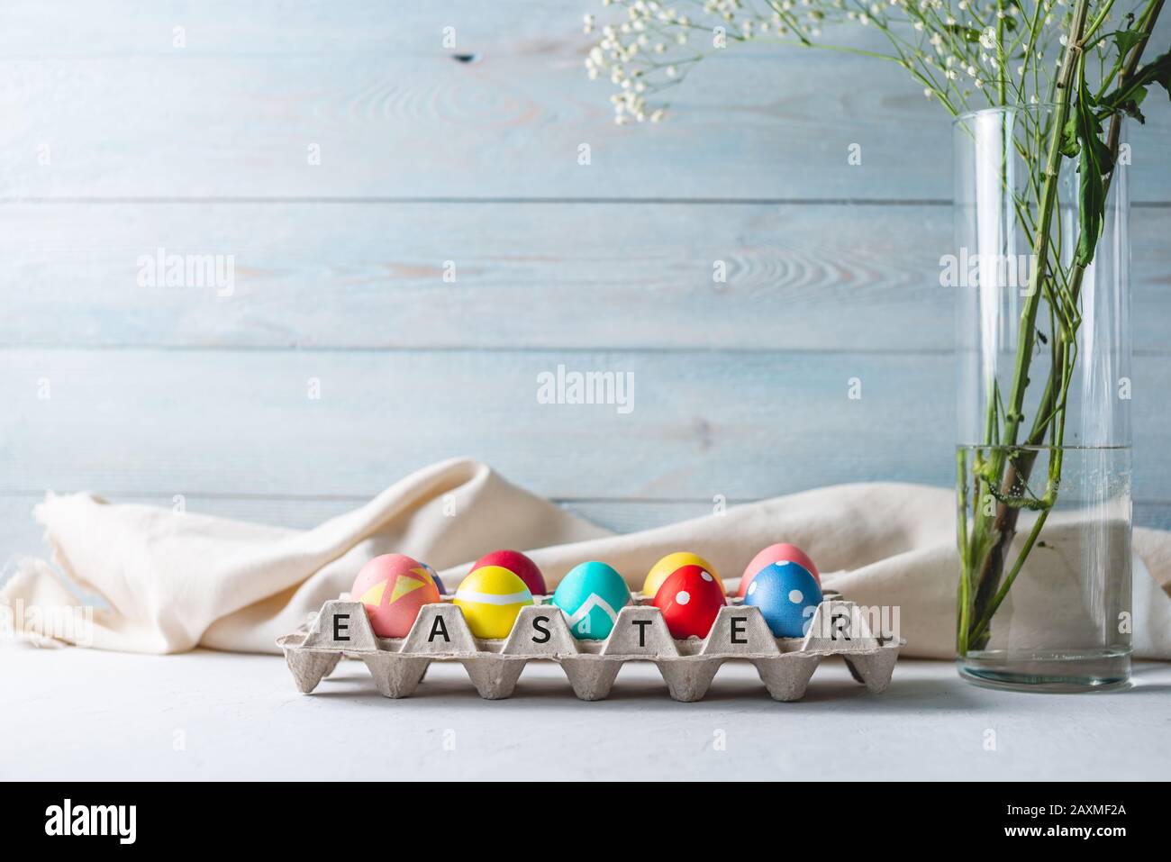 Colorful decorated bright Easter eggs in a tray on a wooden background ...