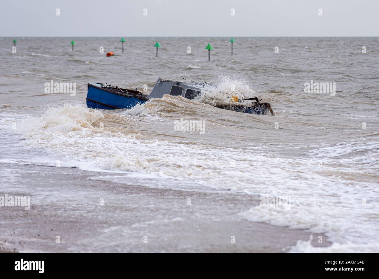 Sinking boat washed up on beach during the high tide storm surge ...
