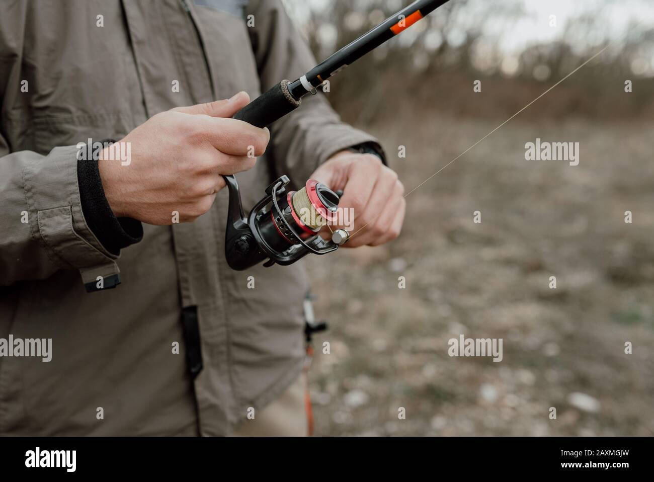 Fisherman holding rod wheel Stock Photo - Alamy