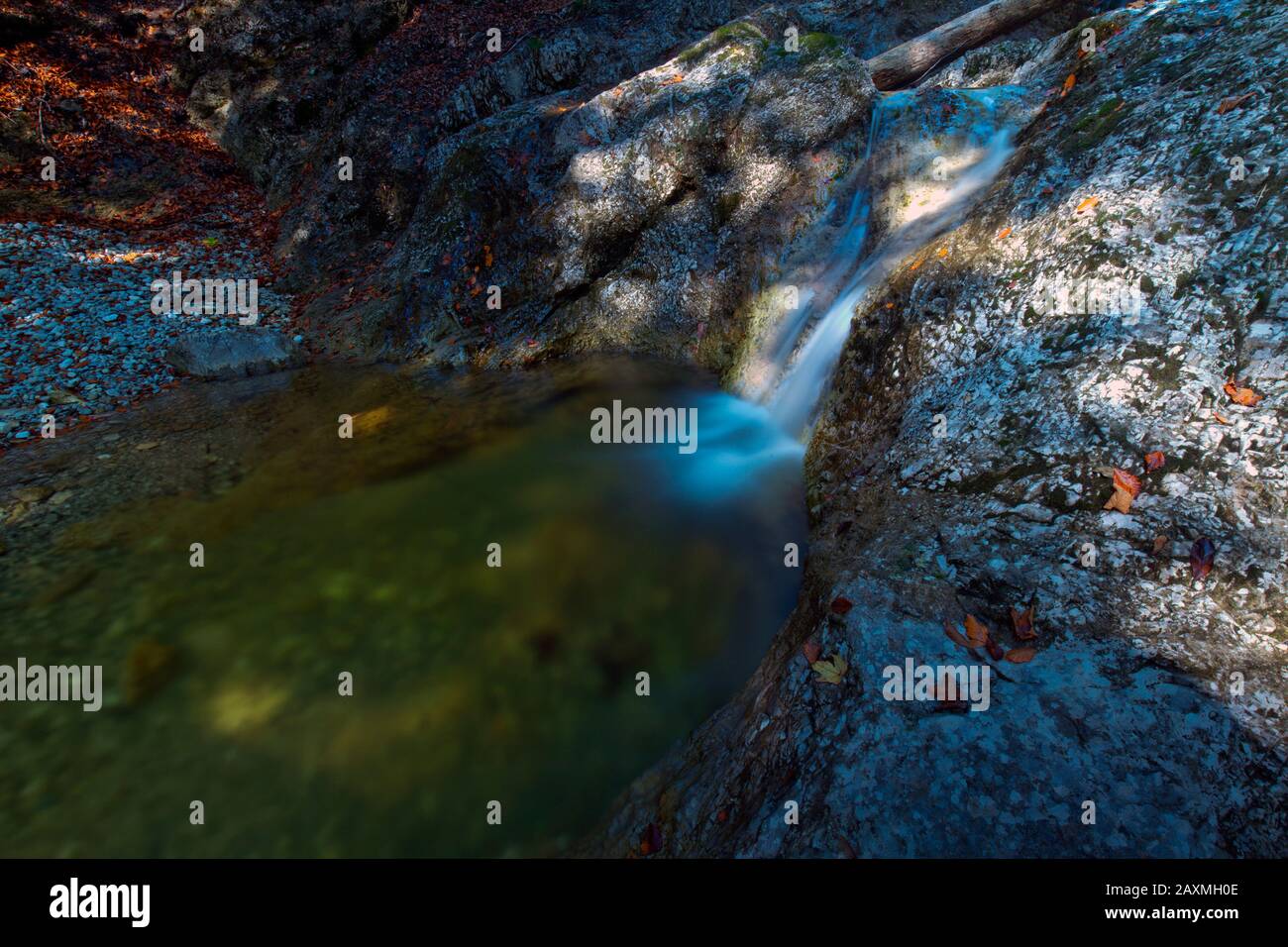 trickle of the mountain stream flowing into small water basin Stock ...