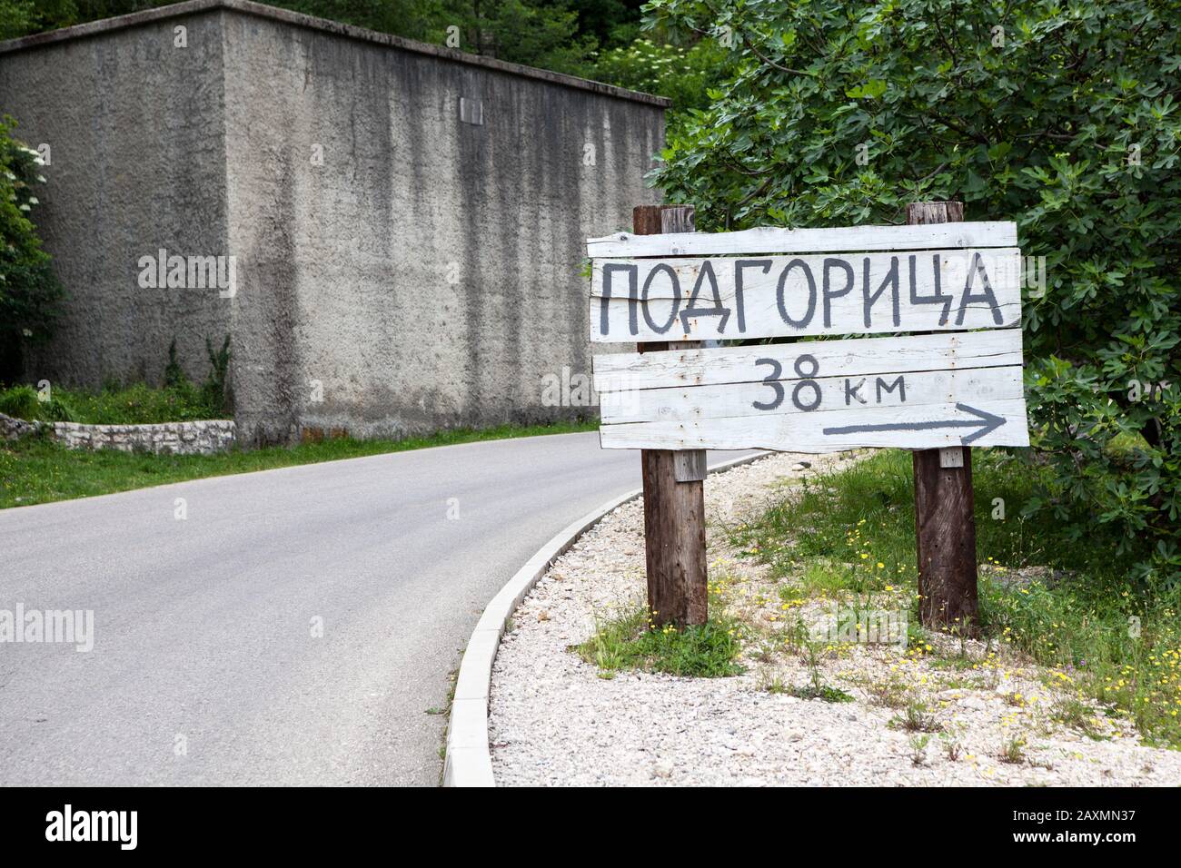 Wooden signpost with direction and distance to Podgorica city in ...