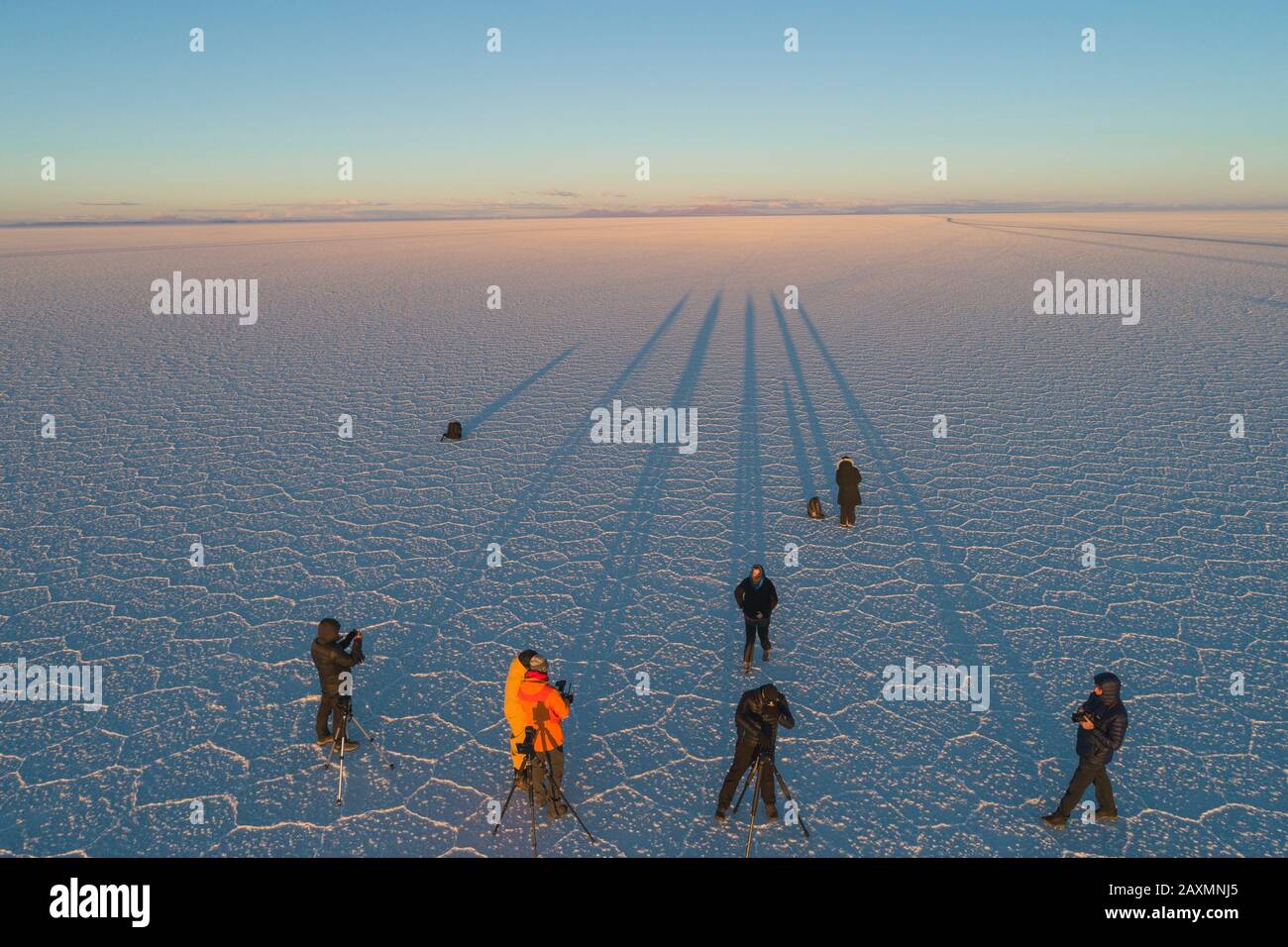 people and their elongated shadows while photographing the salar Stock ...