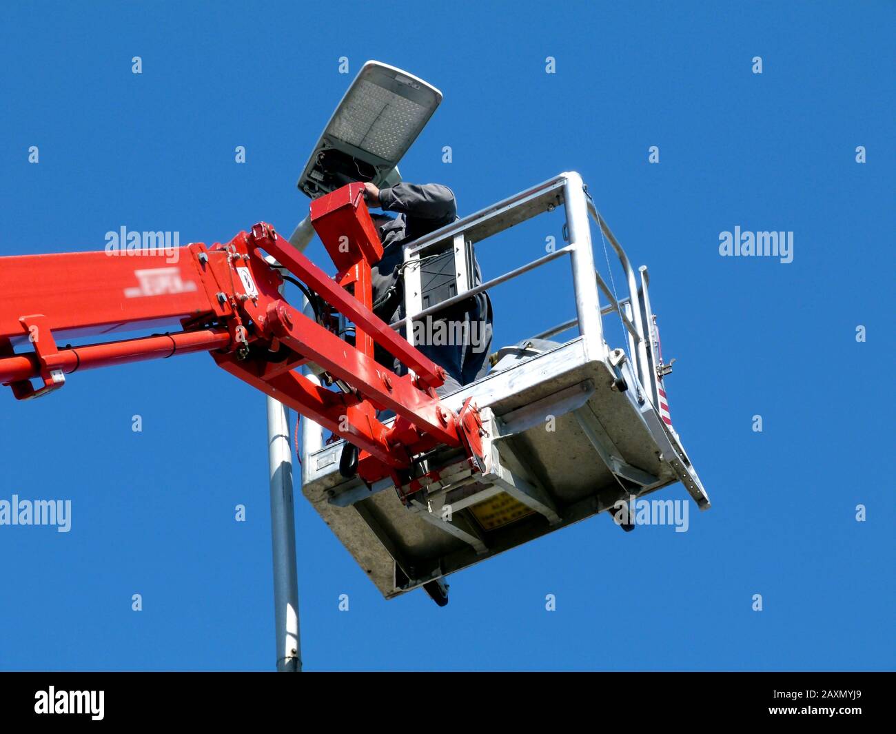street light maintenance at high level from hydraulic lift boom and ...