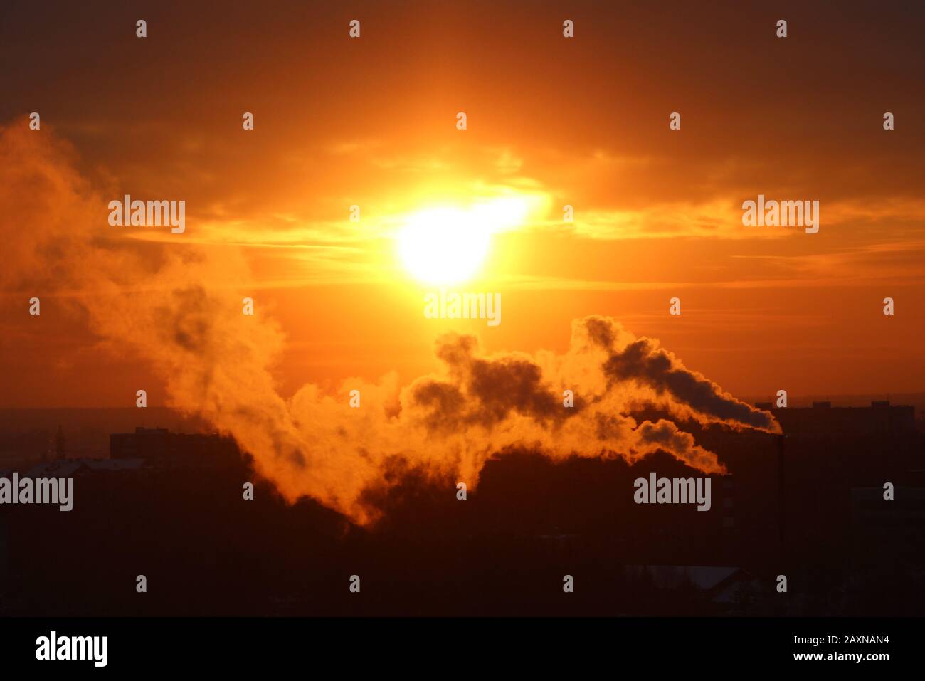 Red sun at sunset or dawn at dusk low above the horizon shrouded in ...