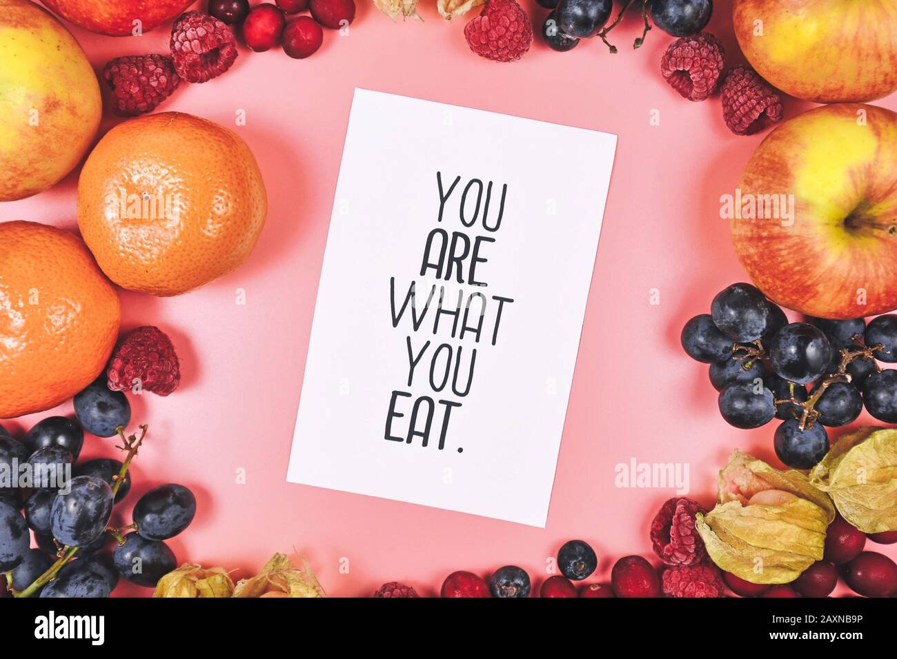 Healthy eating concept with 'You are what you eat' card on pink ...