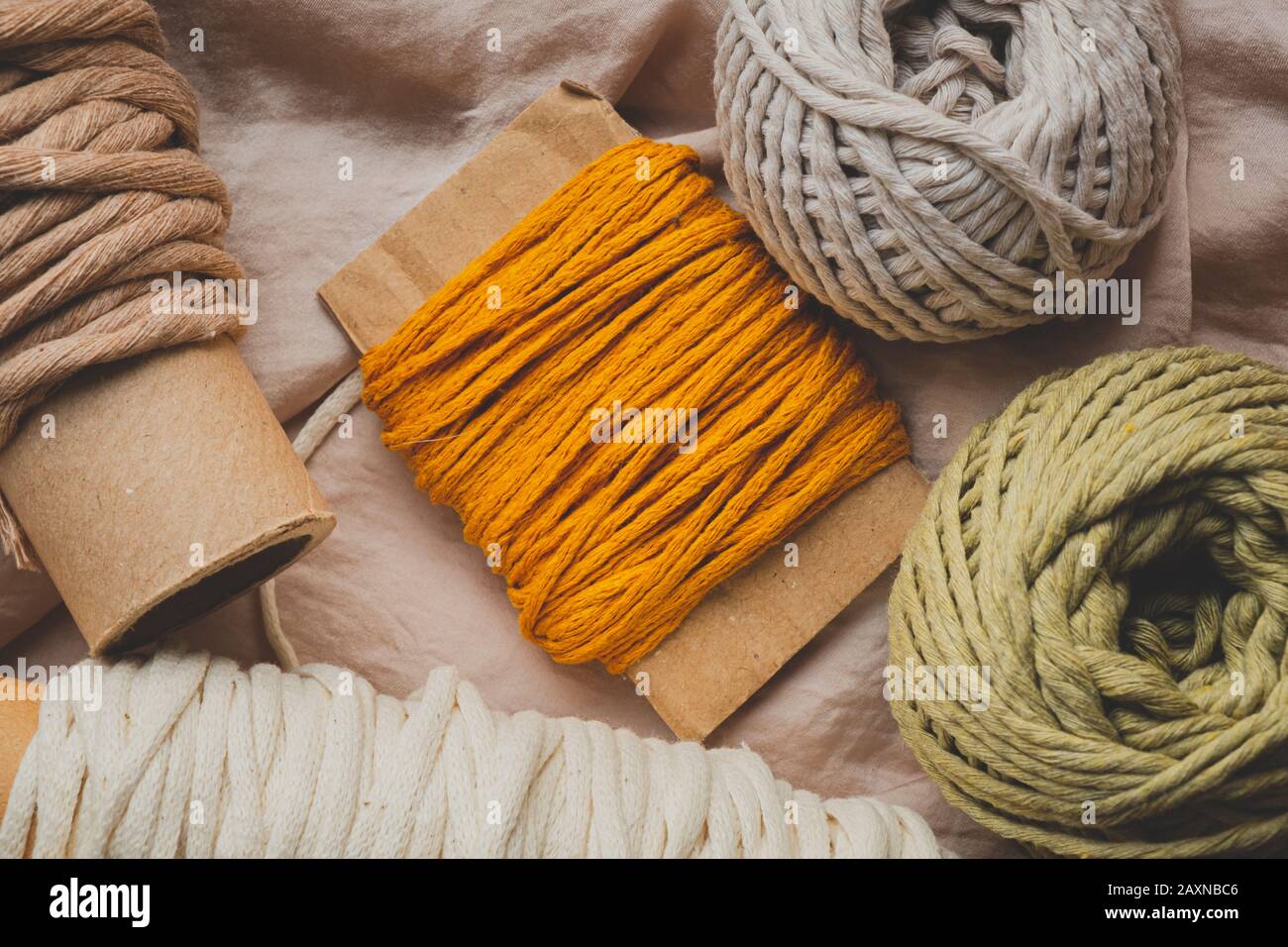 Macrame ropes in various colors, top view. Mustard, red, olive and ...