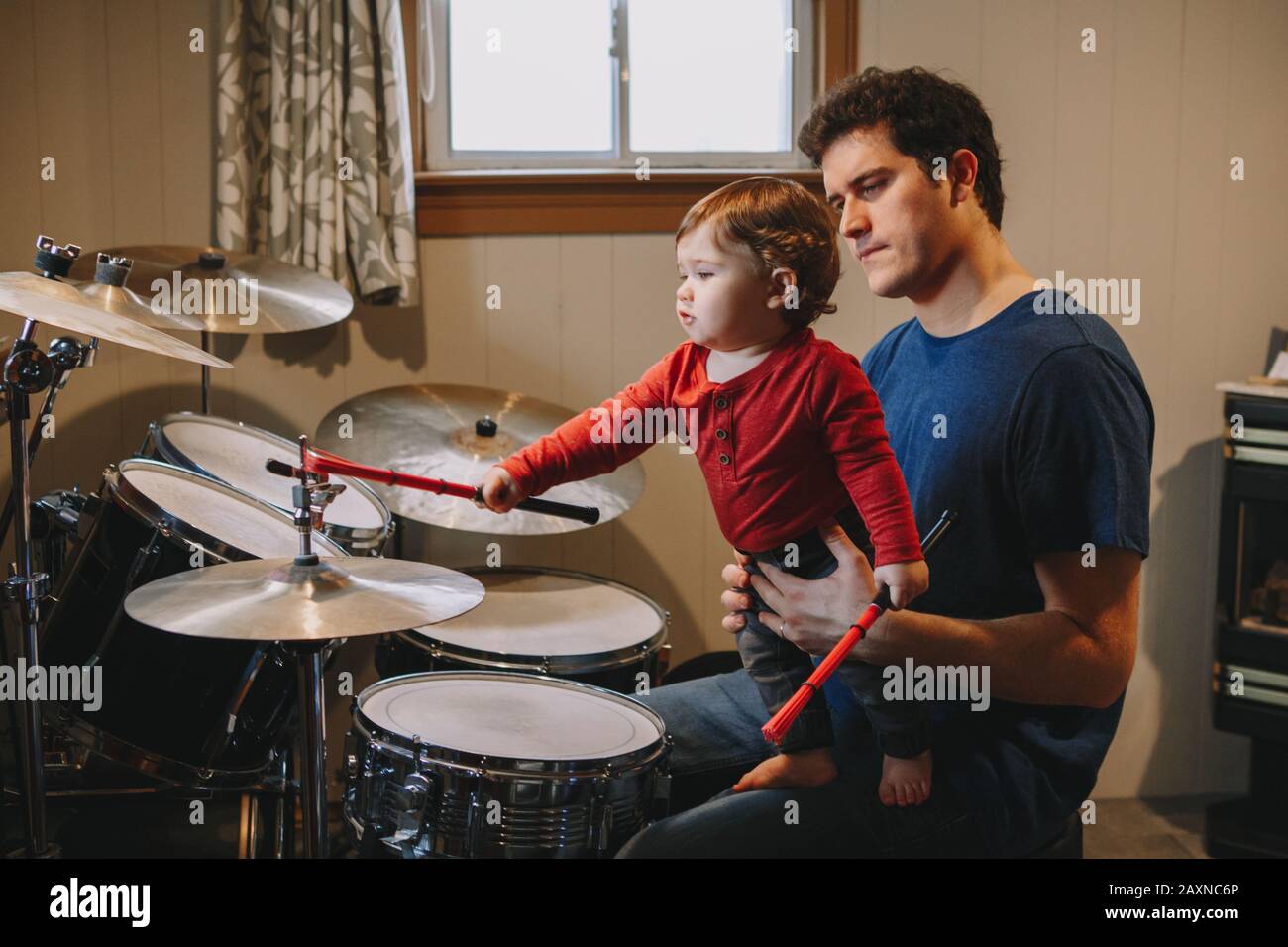 Father teaching baby boy to play drums. Parent with toddler child ...