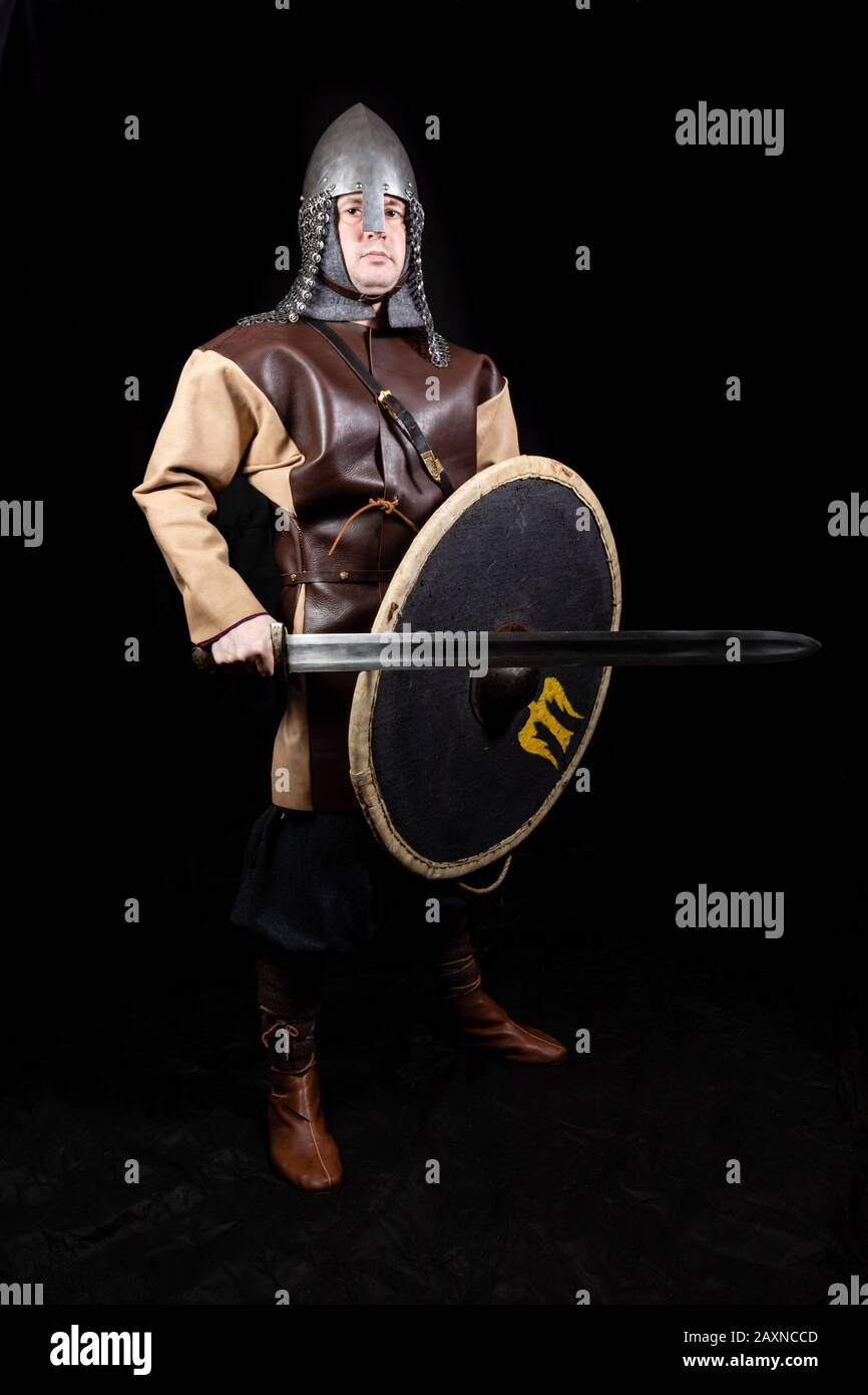 Viking warrior with a shield, sword and ax in a pose of threat, studio ...